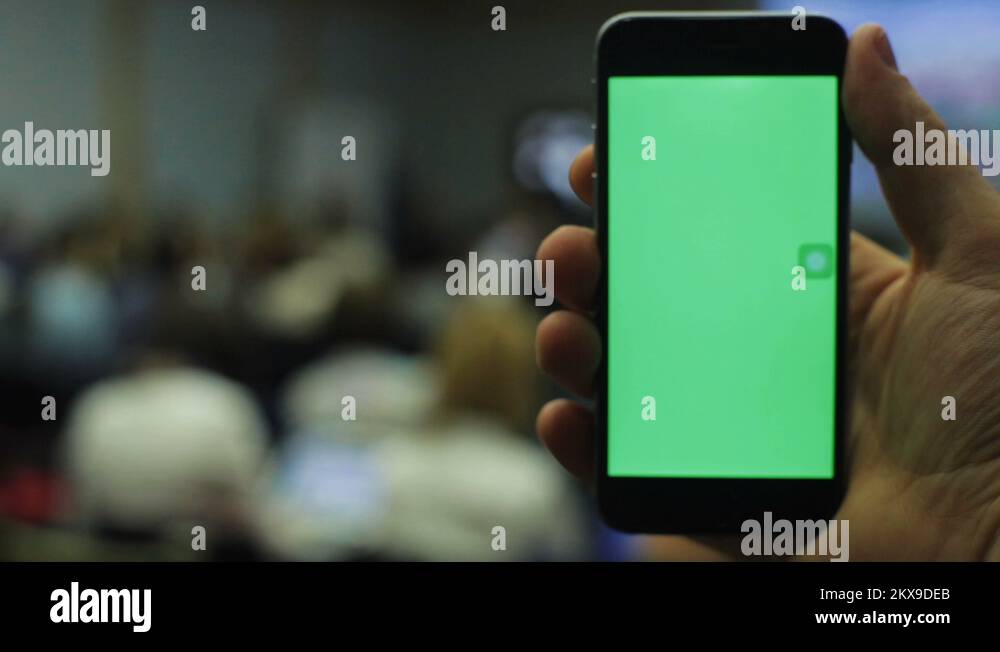 Close-up of a man's hand holding a phone with a vertical green screen in the Stock Video Footage ...