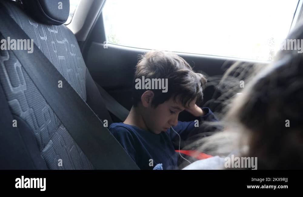 4k, slow motion. brother and sister twins, ride in the back seat of the ...