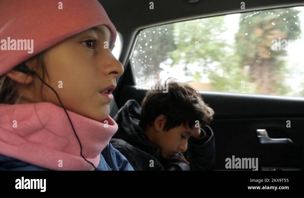 4k, slow motion. brother and sister twins, ride in the back seat of the ...