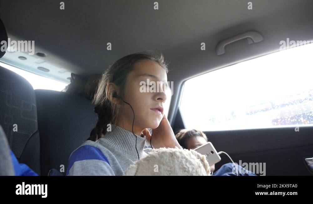 4k, slow motion. brother and sister twins, ride in the back seat of the ...