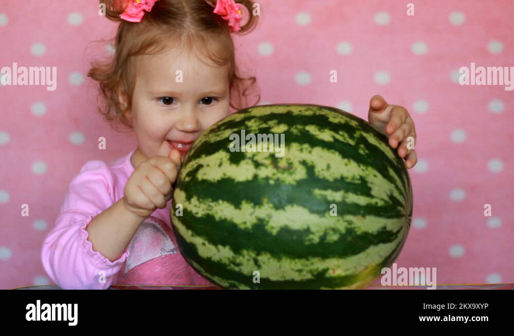 Funny cheerful happy little girl holding a big watermelon. The concept ...