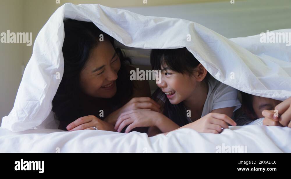 Family relaxing together under a blanket in bedroom 4k Stock Video ...