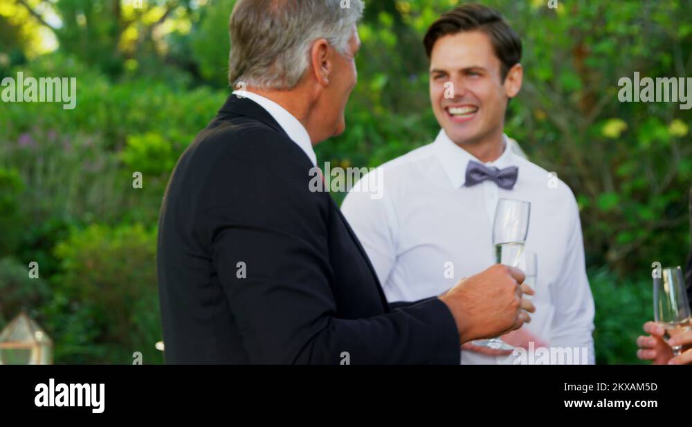 Father of the Bride toasting champagne with groom and guest 4K 4k Stock ...