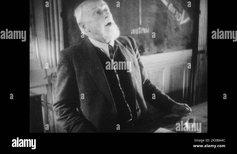 1950s: Old professor talks. University students sit in lecture hall ...