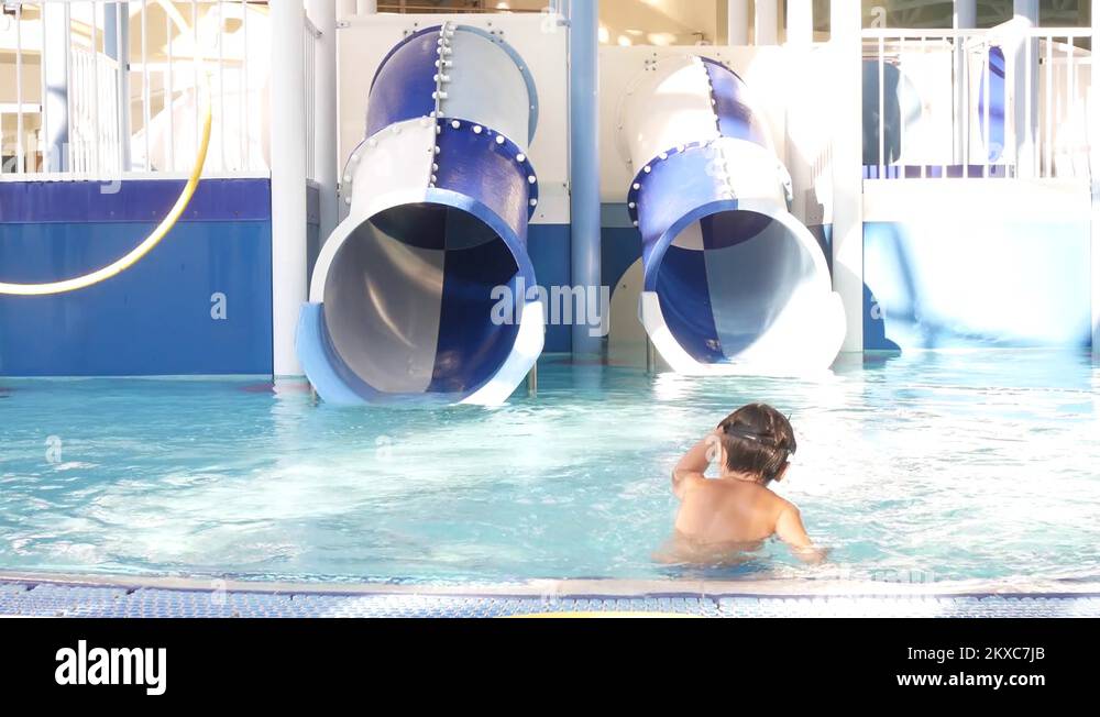 the little boy is practicing in the pool with water slides. 4k Stock ...