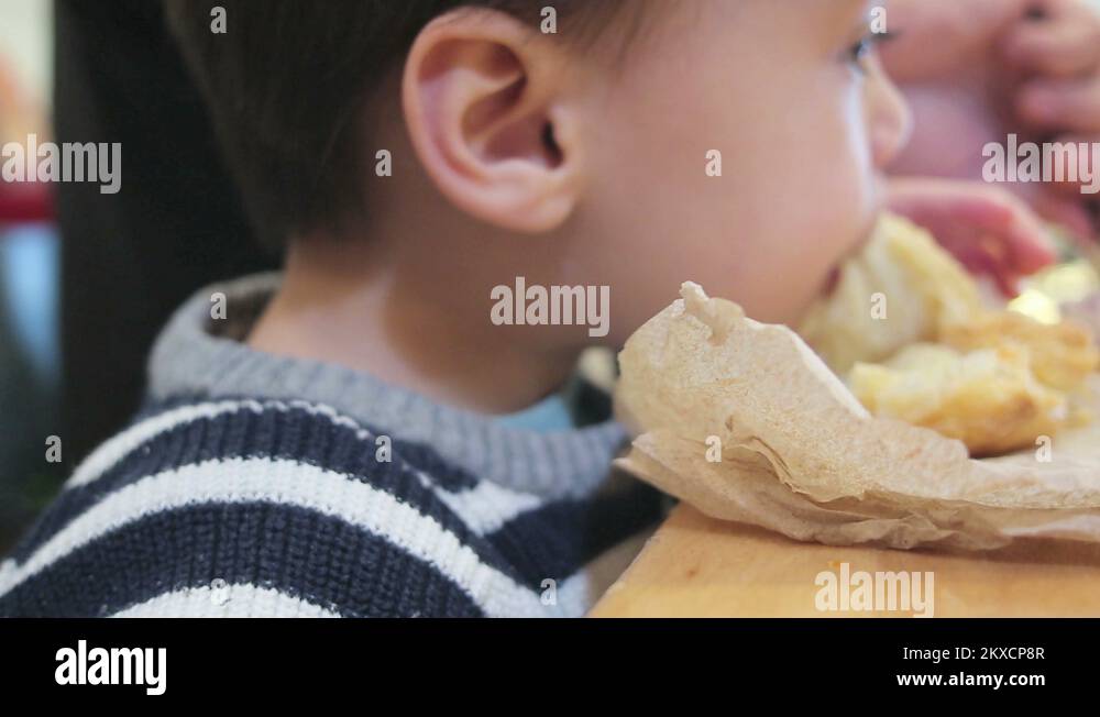 Young boy eating at a bakery Stock Video Footage - Alamy