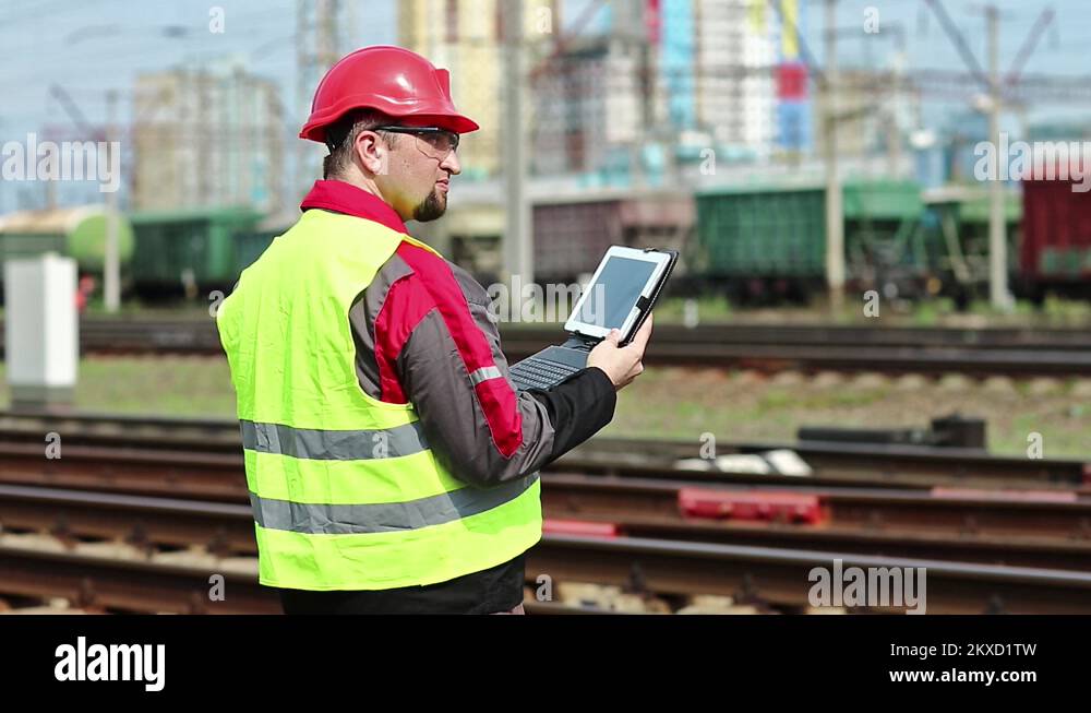 Railwayman with computer at freight train terminal Stock Video Footage ...
