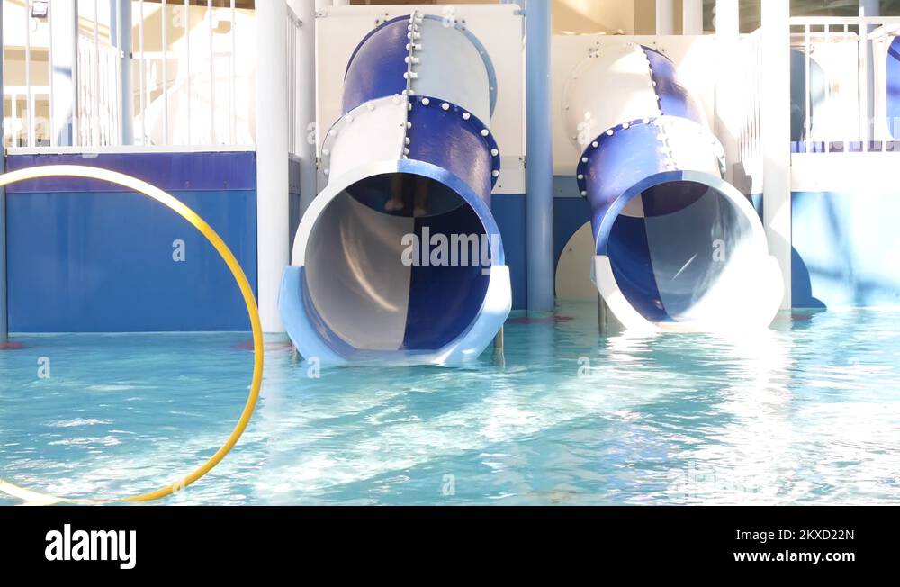 children swim in the pool, roll down from the water slide 4k, slow ...