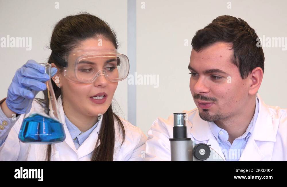 Close up scientists team group portrait mixing chemistry flask smile to ...