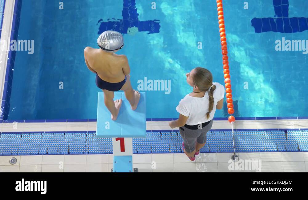 swim athlete training. The coach teaches the boy to dive into the ...