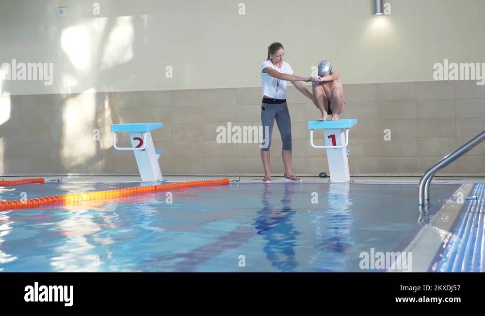 swim athlete training. The coach teaches the boy to dive into the ...