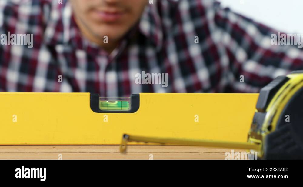 Male architect measuring plywood with engineer scale against white ...