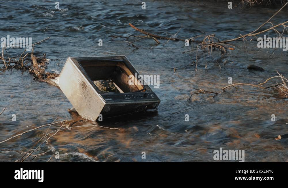 retro TV in river after flood.debris from houses. Pollution of the ...