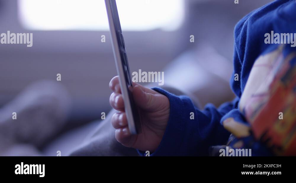 Young boy holding smart tv remote control - extreme close up on tiny ...