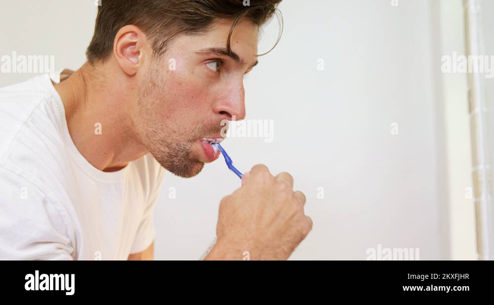Young man brushing his teeth with toothbrush in the bathroom 4K 4k ...