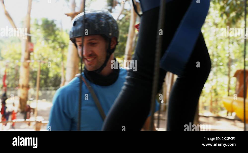 Man assisting children to cross zip line in the forest 4K 4k Stock ...