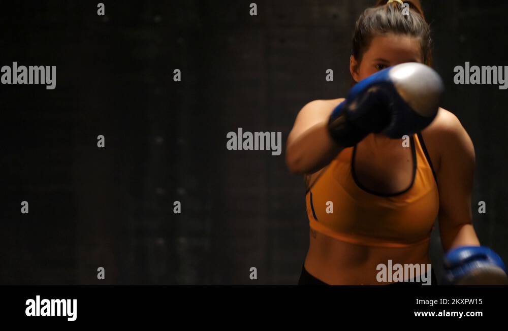 Strong woman fighter martial arts training punches with hands on boxing ...