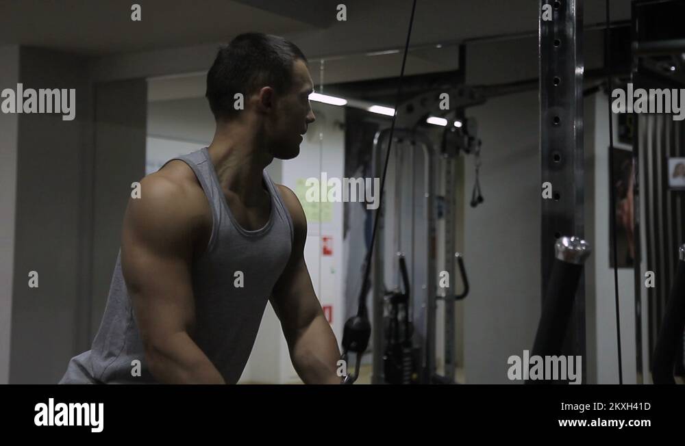 The portrait of bodybuilder who is pulling the weight equipment in the ...