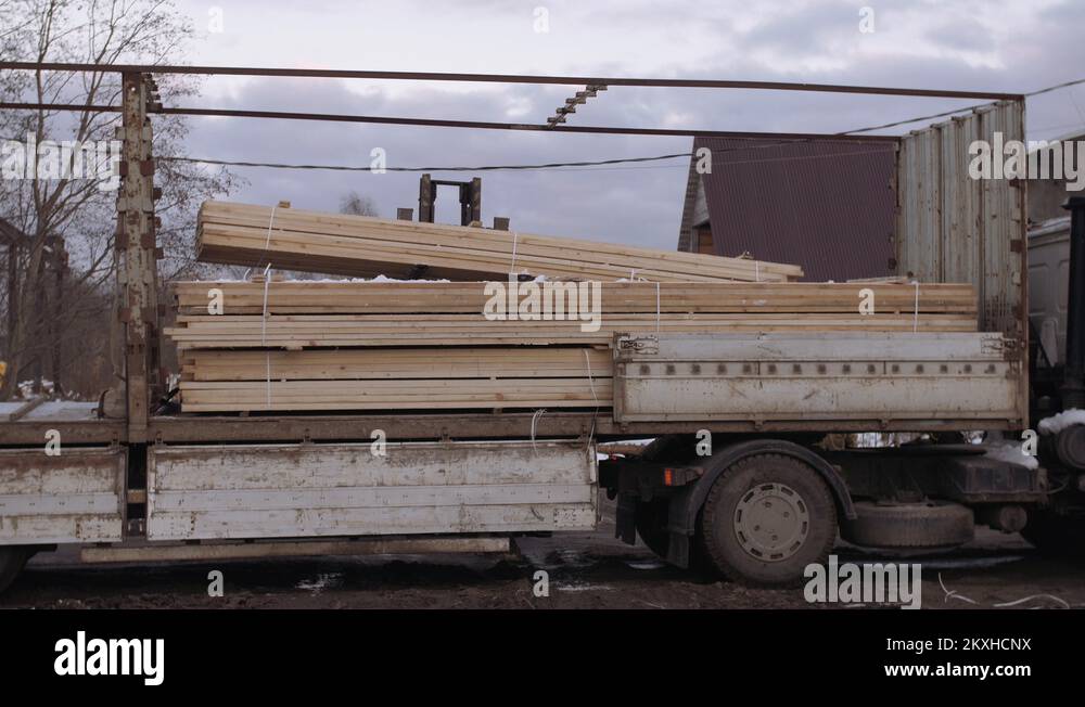 Forklift uploads heavy truck with wood block stacks at woodwork ...