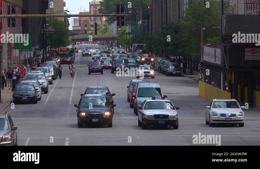 Chicago street scene. Busy traffic head on with cyclists and skater ...