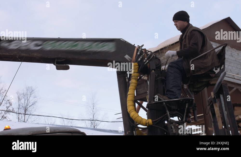 Mechanical claw loader unloads lumber scraps from heavy truck at ...