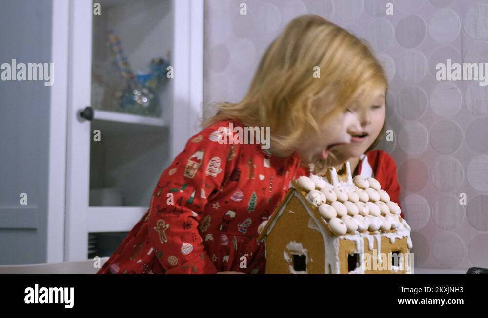 Kids eating an gingerbread house, two little girls sitting and eating ...