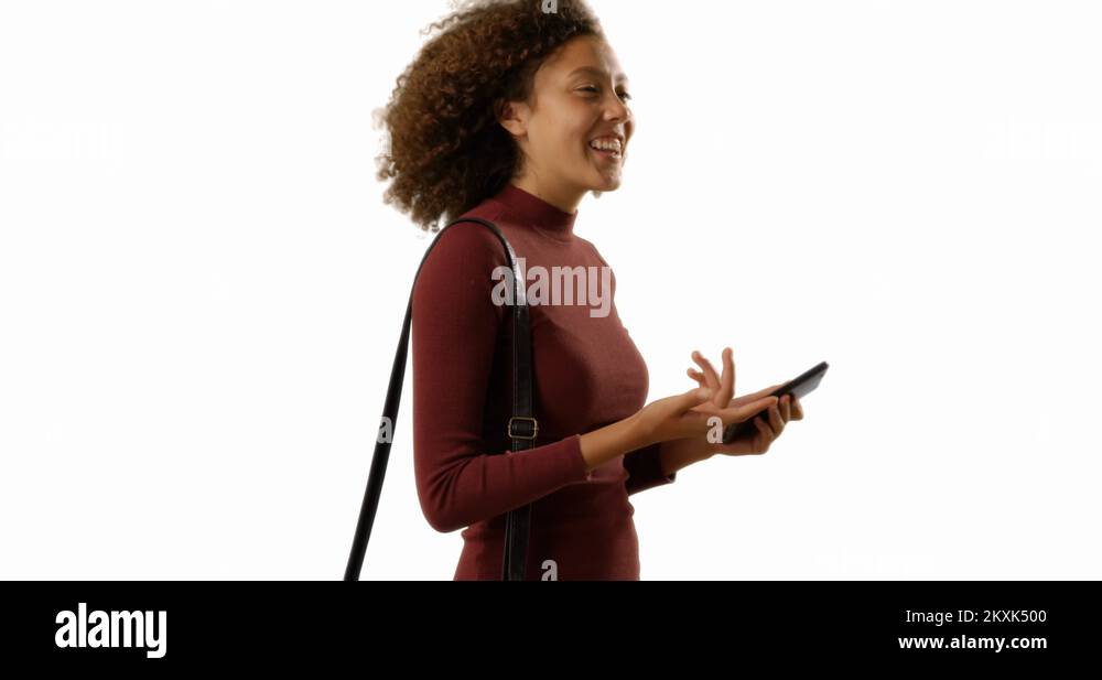 Pretty black woman talking to someone off camera on white background ...