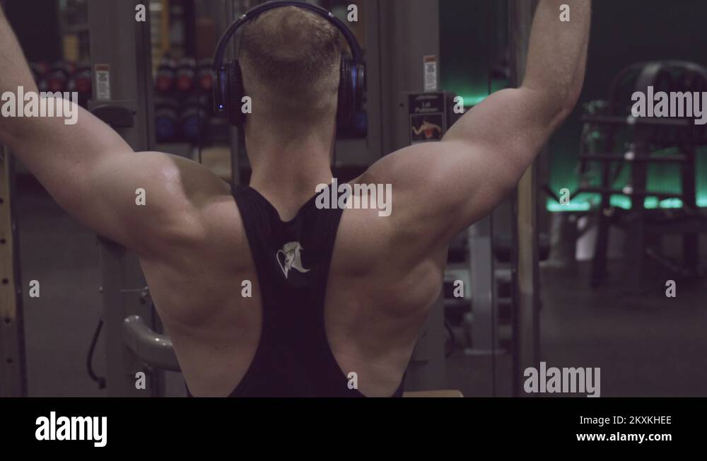Strong man bodybuilder doing lat pull down and working back out in the ...