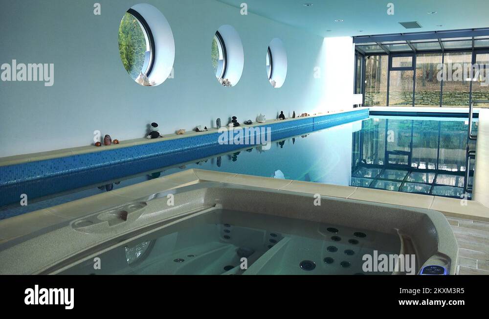 An indoor swimming pool and a whirlpool bath in a luxurious house Stock ...