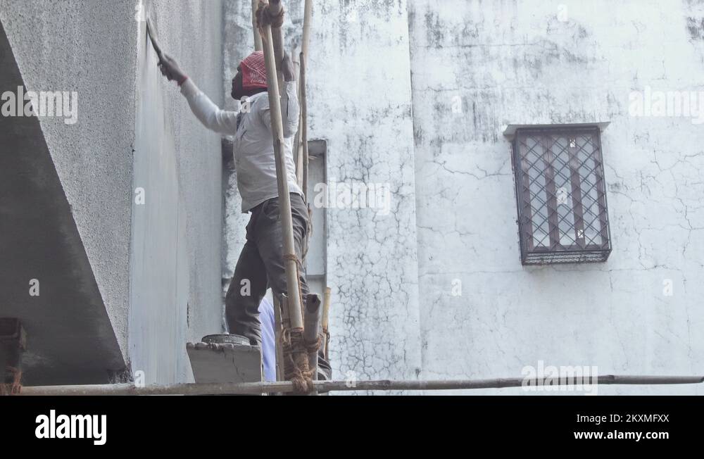 construction workers working scaffolding on a building construction ...