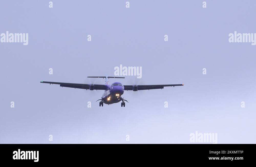 Turbo prop plane flying over low in cloud Manchester airport 4K Stock ...