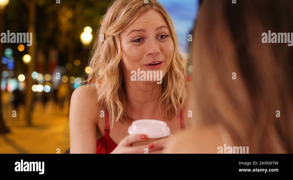 Beautiful blonde girl being social with friend in Champs Elysees, Paris ...