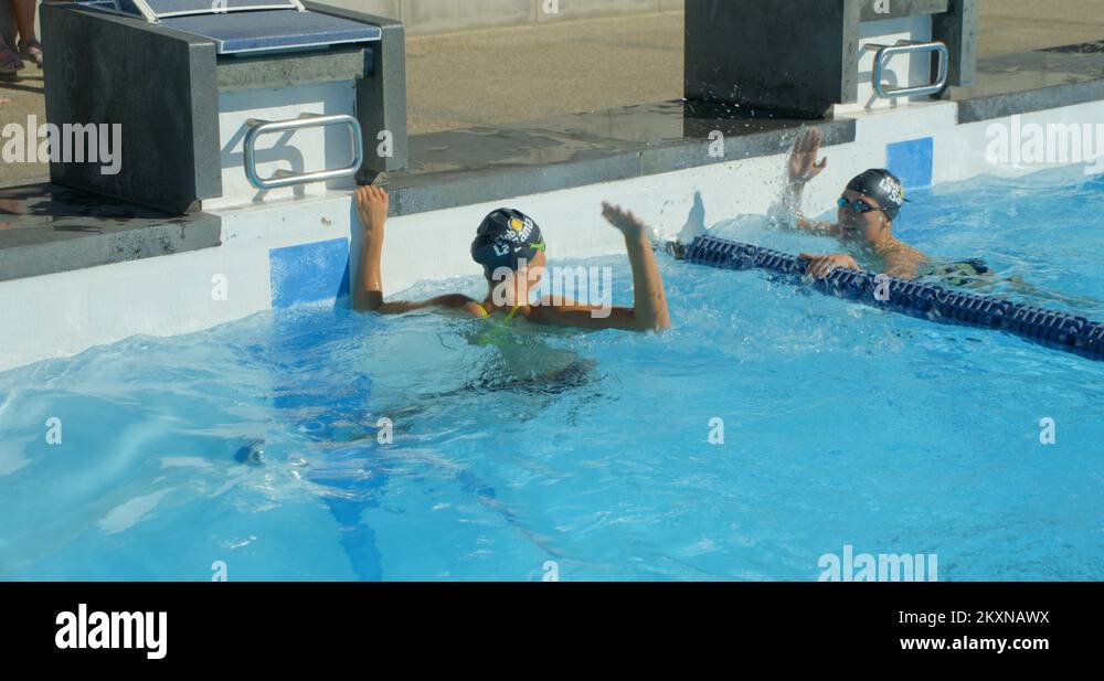 Two female swimmers celebrate with a high five and a fist bump Stock ...