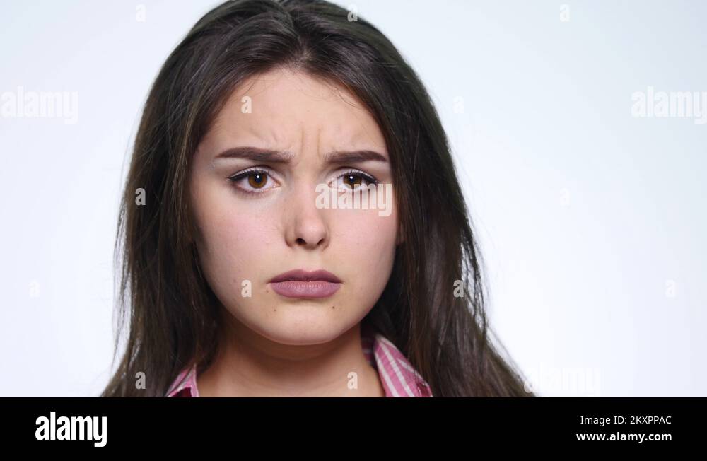 A cute young woman makes a sad face on a white background Stock Video ...