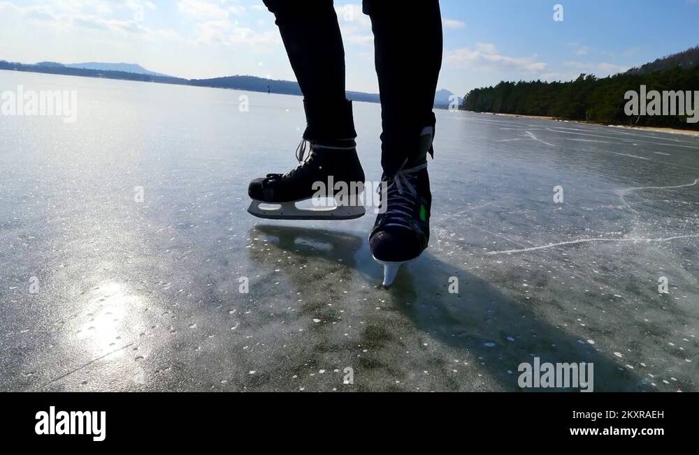 Long male legs in black leggins with hockey skates. Outdoor ice skating ...