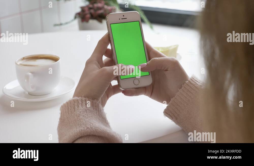 Beautiful female hands using a smartphone in a cafe, green screen ...