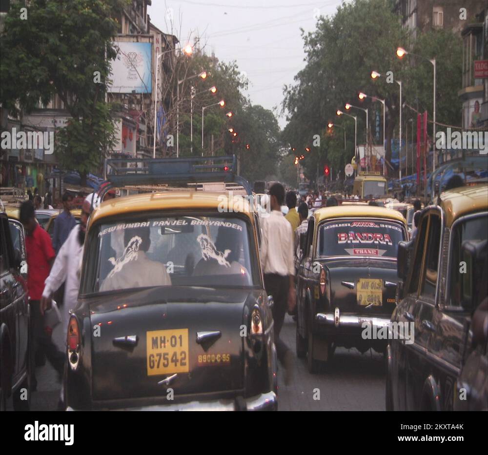 POV waiting at traffic light with taxis, mny pedestrians walking ...