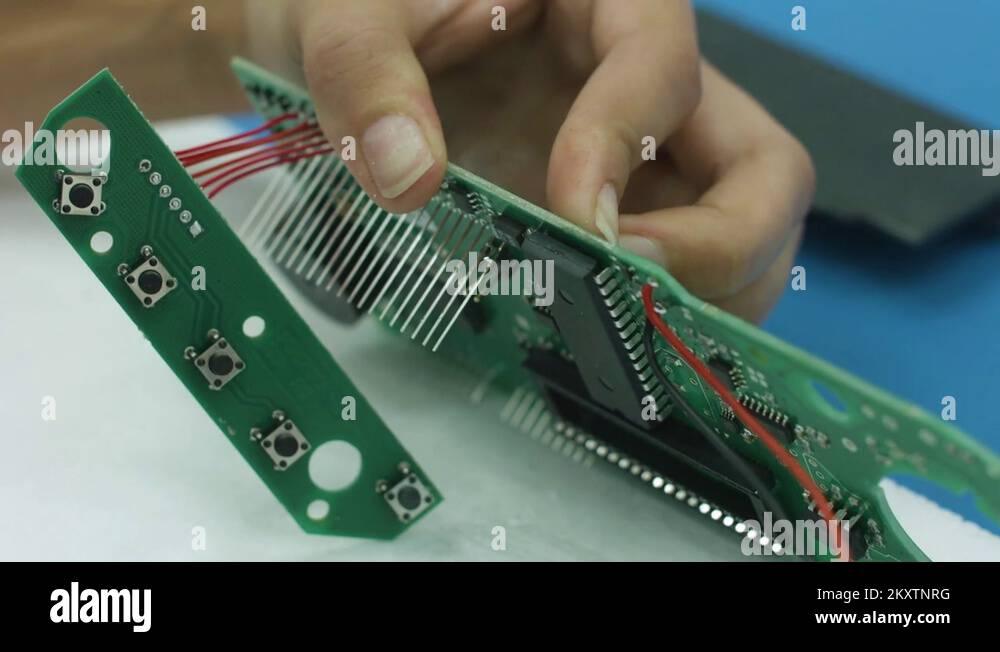 Industrial setup. Factory worker soldering components on a printed ...