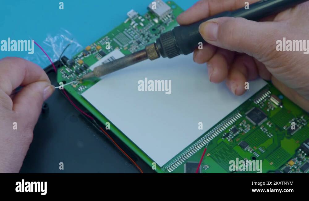 Industrial setup. Factory worker soldering components on a printed ...