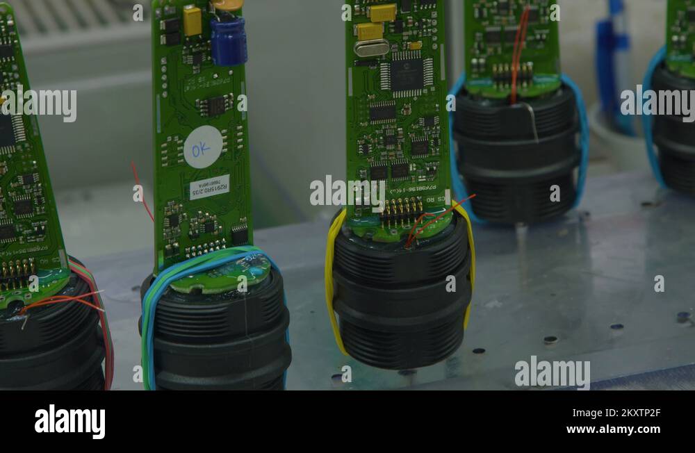 Industrial setup. Factory worker soldering components on a printed ...