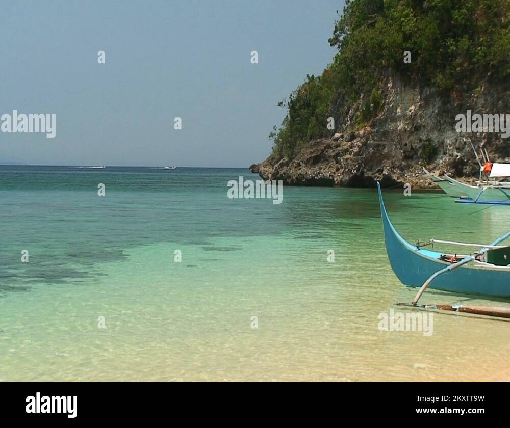 Traditional filipino Banka outrigger boat laying on a beach in ...