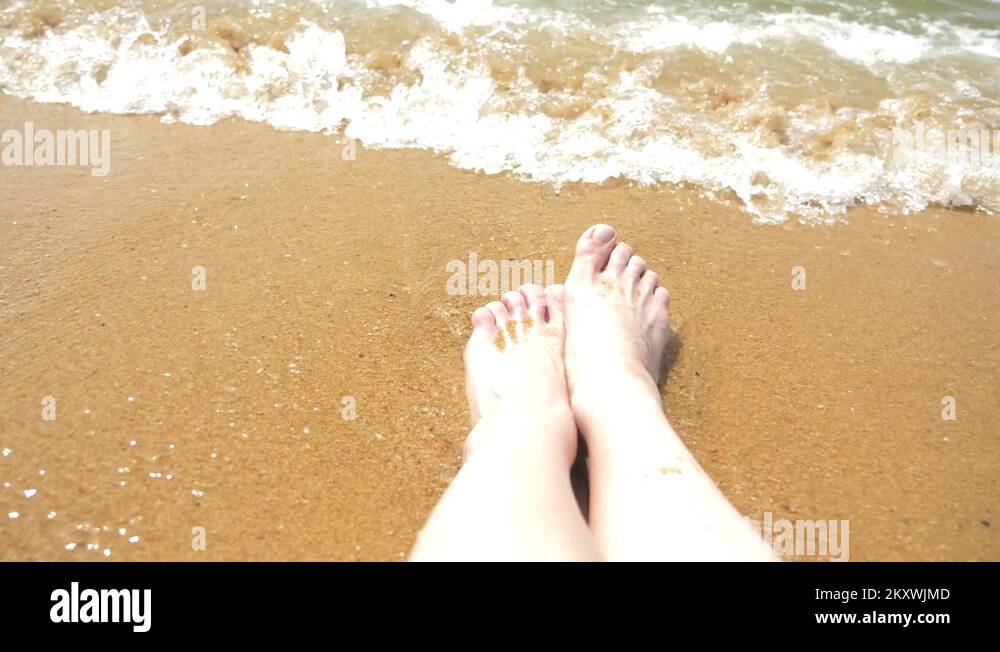 female feet on the sand, the sea wave covers the female legs. 4k, slow motion Stock Video ...