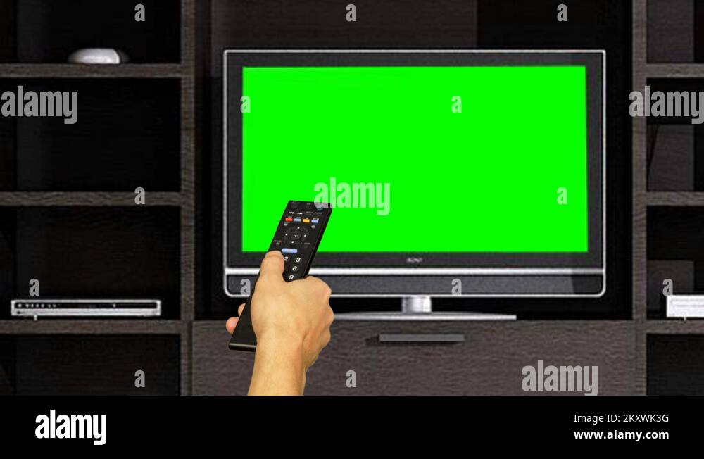 Hand using remote control for switching TV channels on green screen ...
