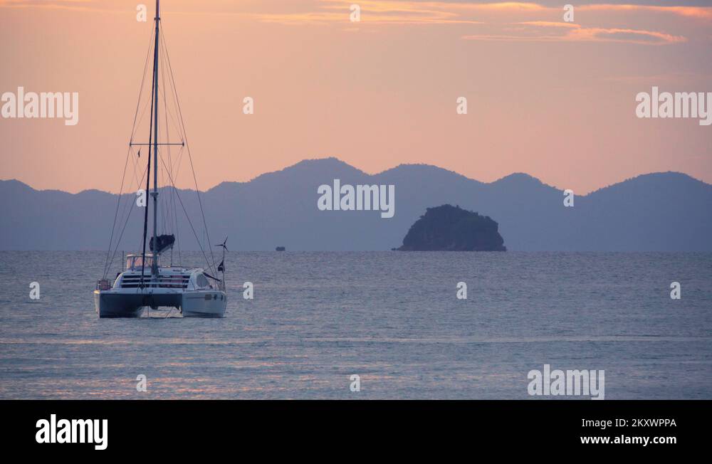 Mast yacht catamaran in the sea with islands on the background at ...