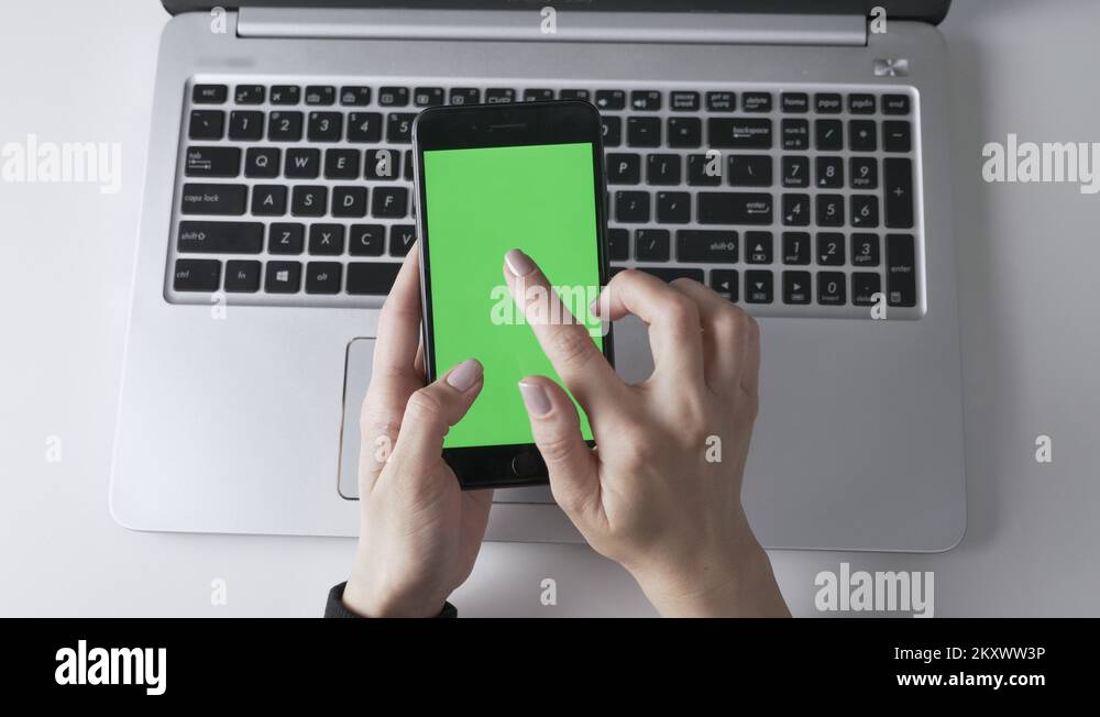 Female hands tap on the smartphone's touchscreen. Green screen ...