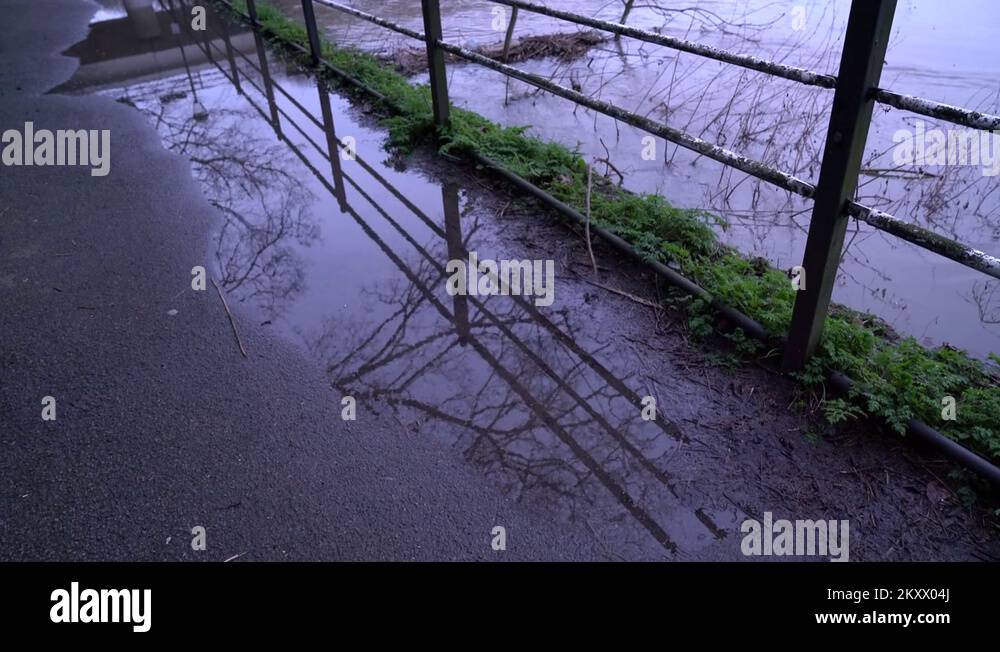 Tilting shot of flooded path to reveal extent of rising water levels ...