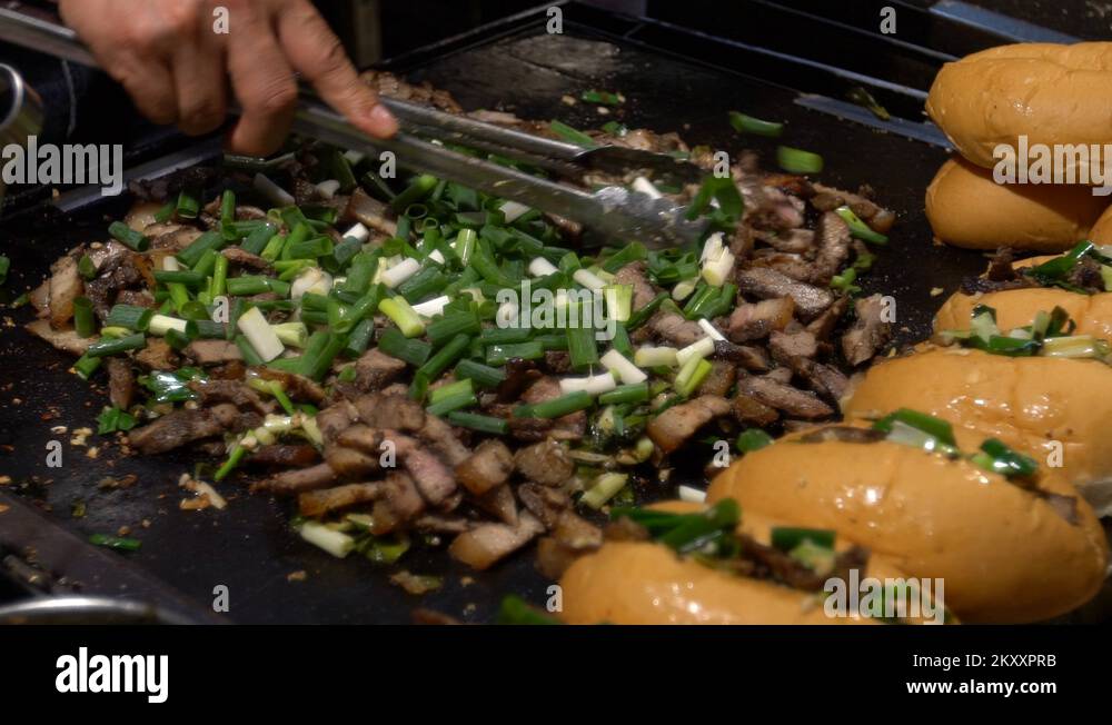 Slow Motion Vendor cooking Taiwanese pork meat on steel grill. Night ...