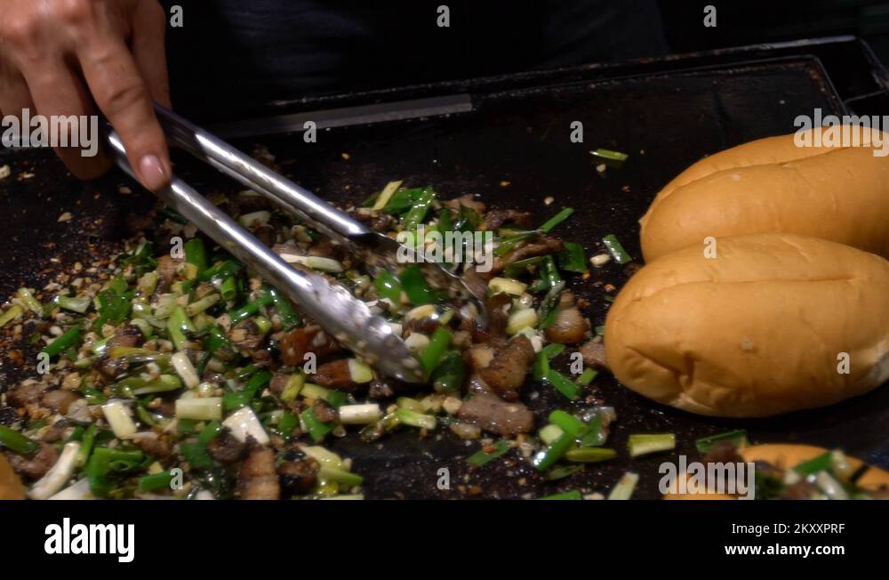 Slow Motion Vendor cooking Taiwanese pork meat on steel grill. Night ...