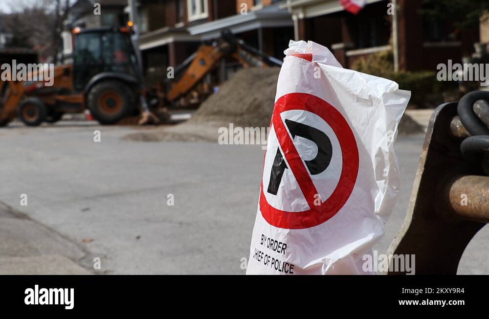 No Parking pilon with construction digger in the back ground. Spring ...