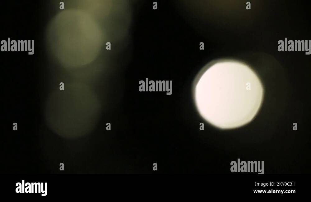 Blinking defocused lights in the dark. Real lens flare and light leak ...